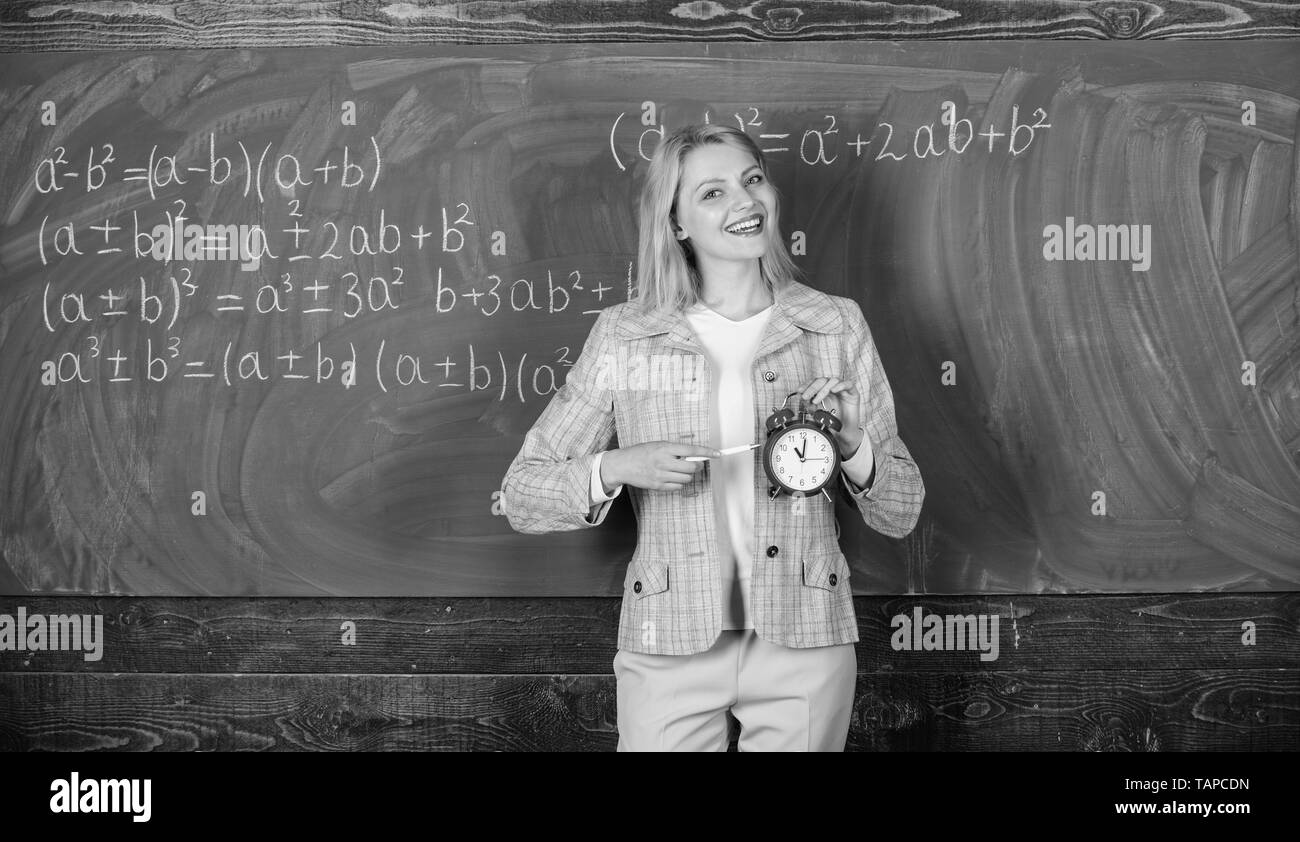 Woman teacher hold alarm clock. She cares about discipline. Time to ...