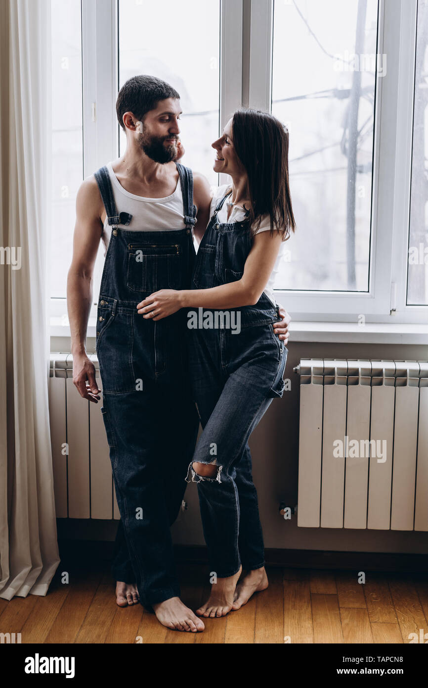 happy couple standing near the window and hug Stock Photo - Alamy
