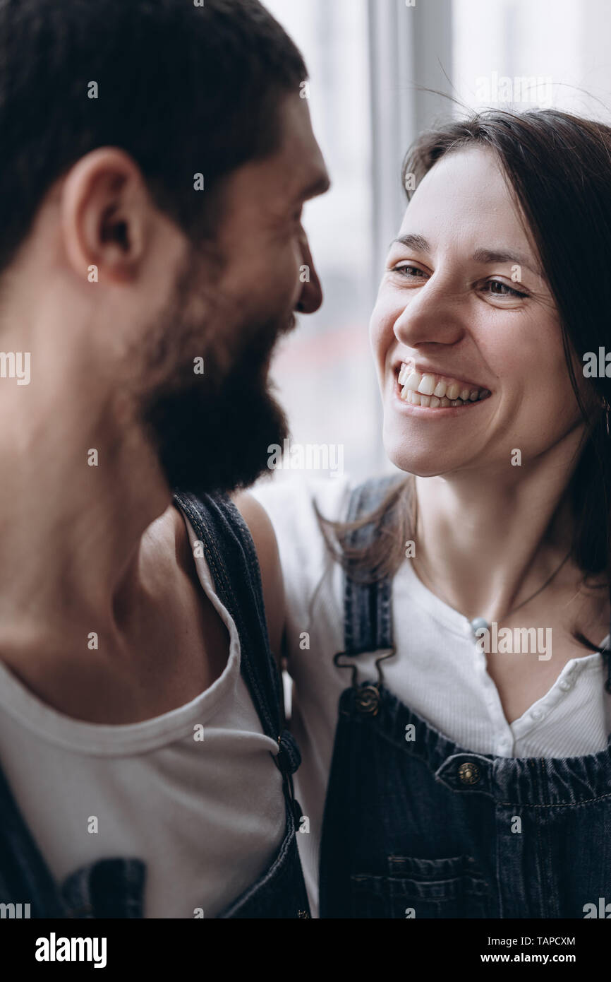 happy couple smile and laugh to each other near the window Stock Photo ...
