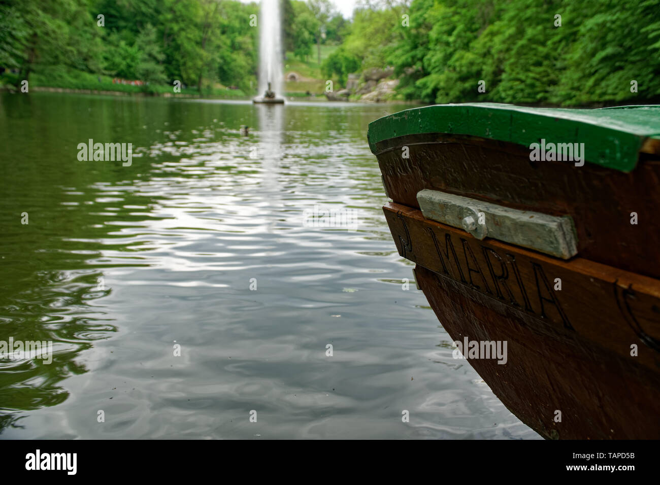 Old wooden boat stern on river and fountain behind Stock Photo - Alamy