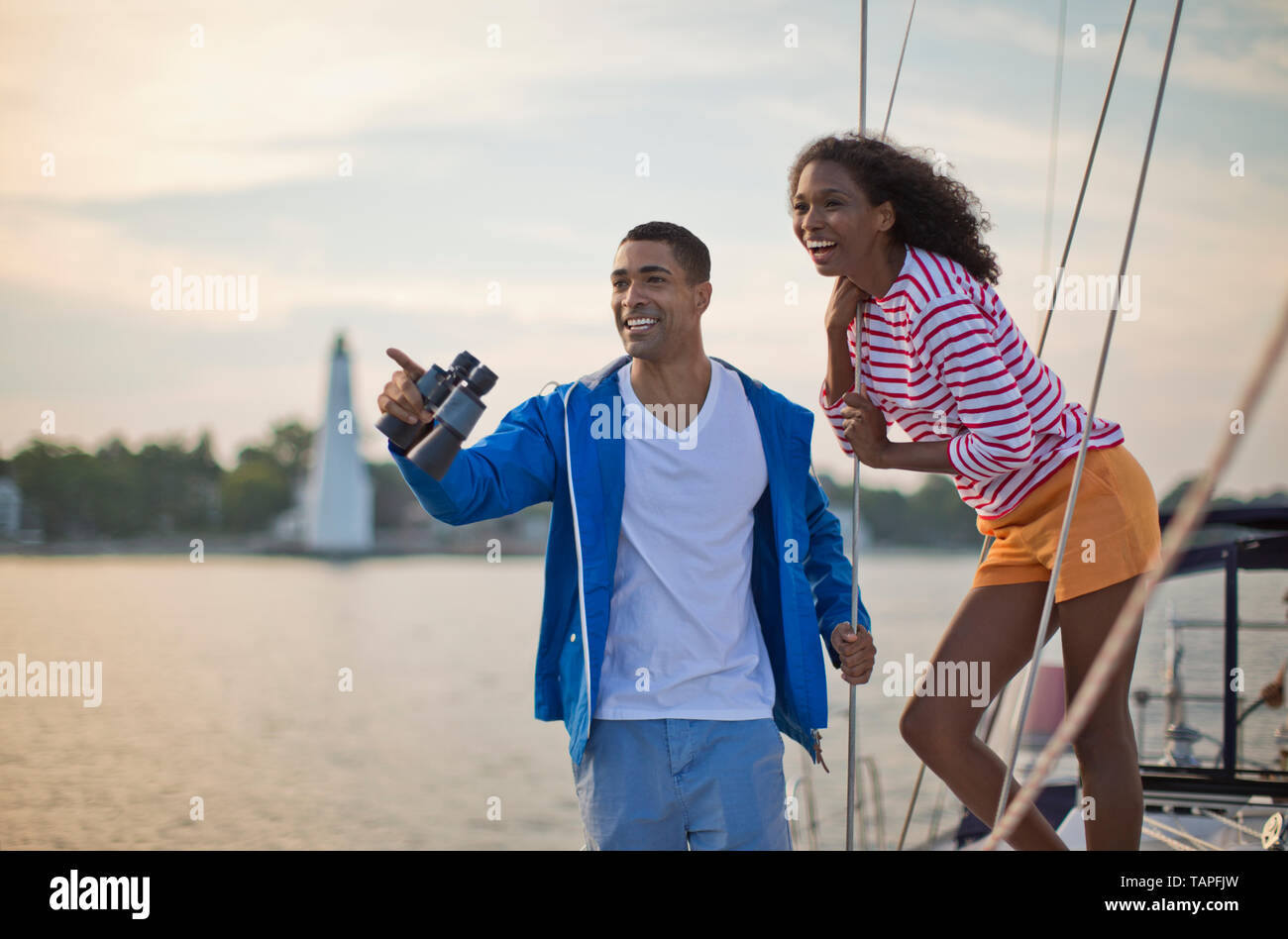 Happy young couple having fun with binoculars while sailing Stock Photo ...