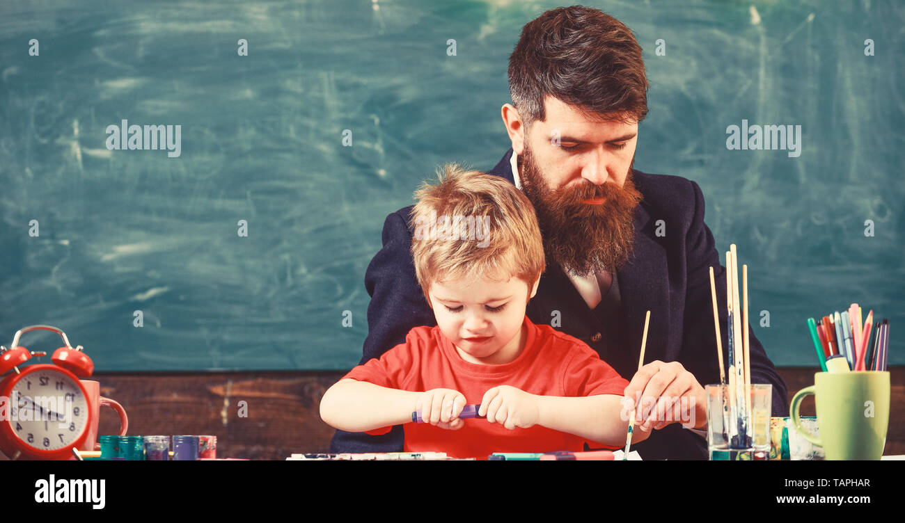 Art lesson at kindergarten. Teacher helping the boy to create picture ...