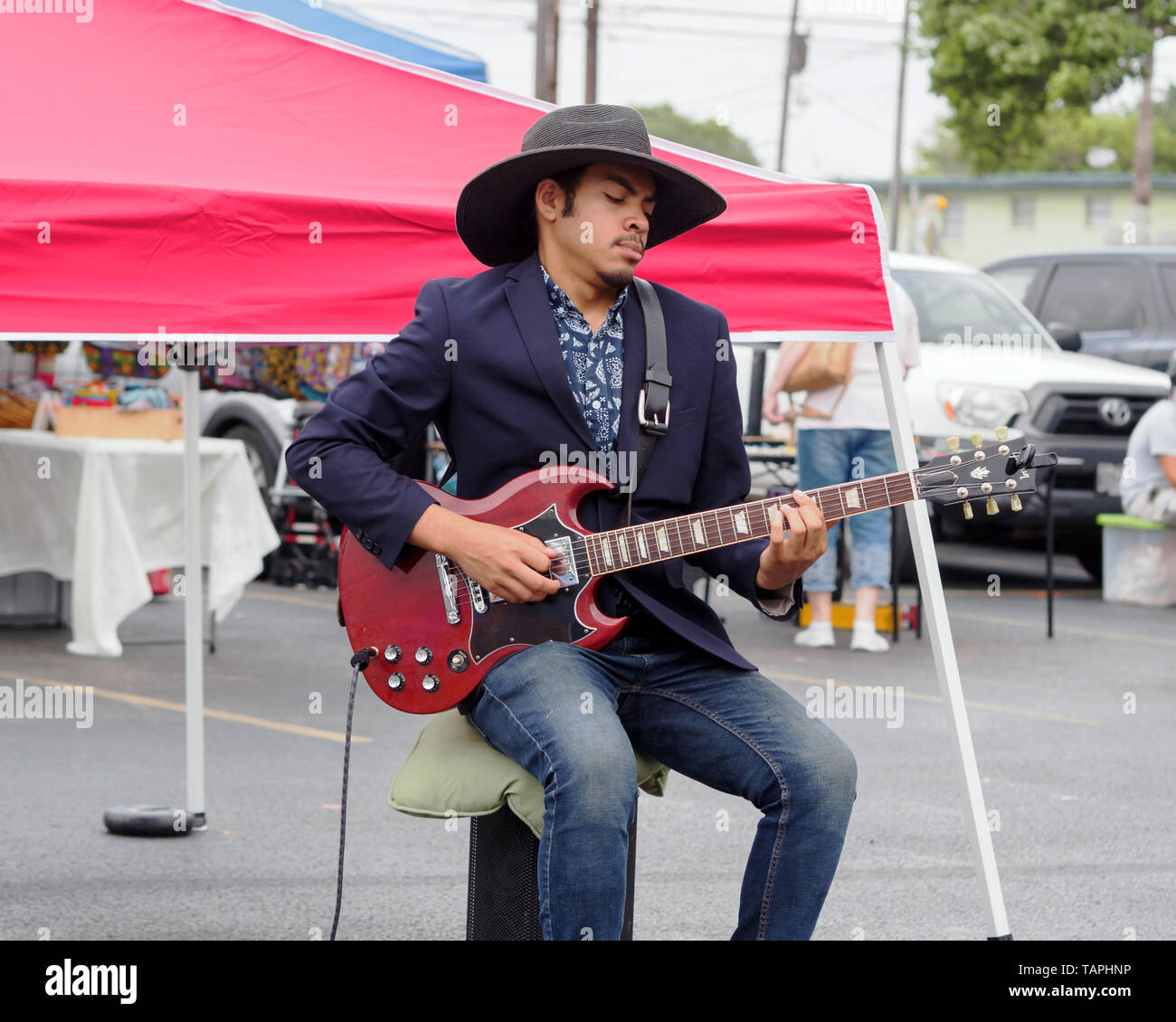 Dark complected young man playing electric guitar outdoors hi-res stock ...