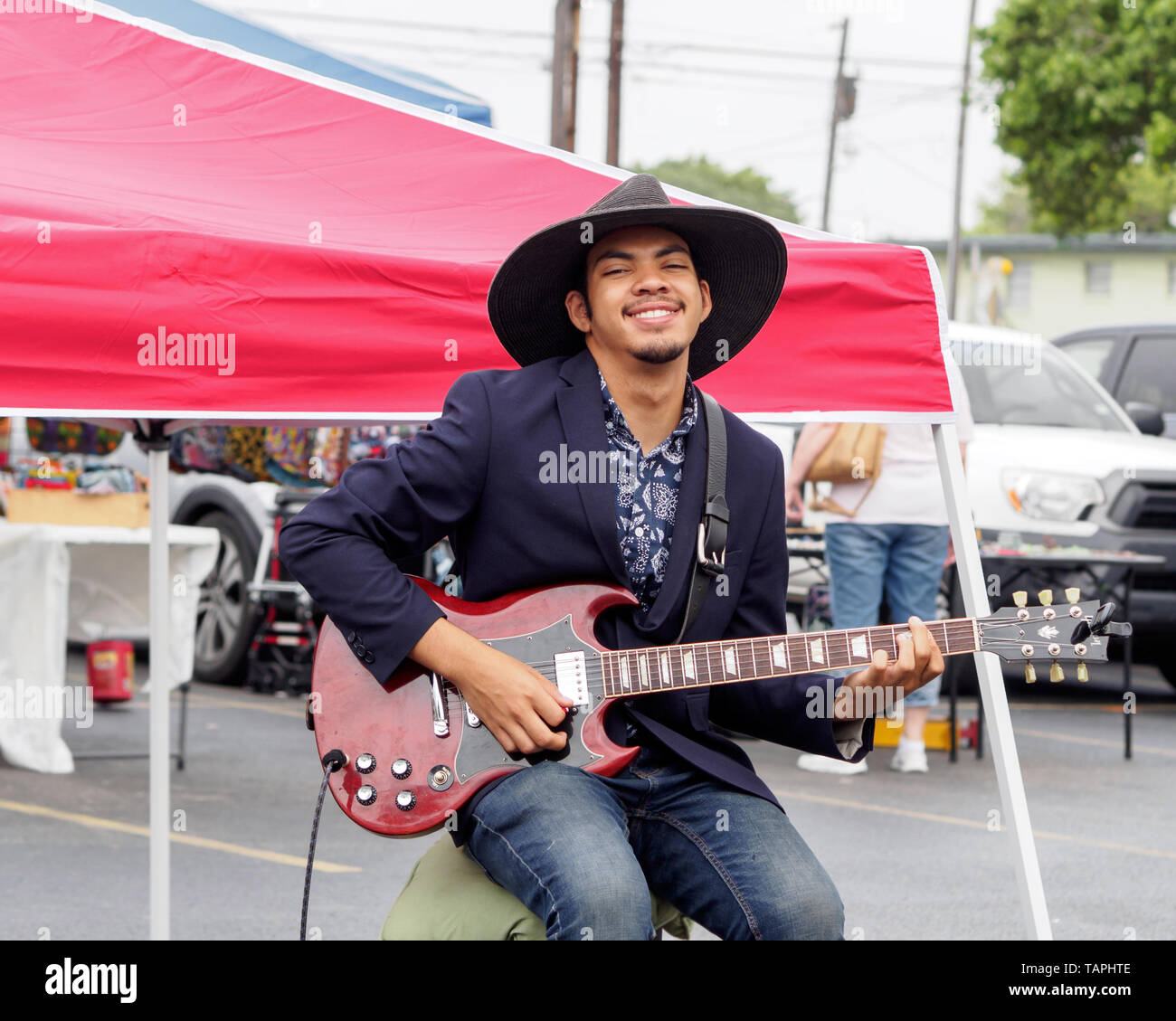 Dark complected young man playing electric guitar outdoors hi-res stock ...