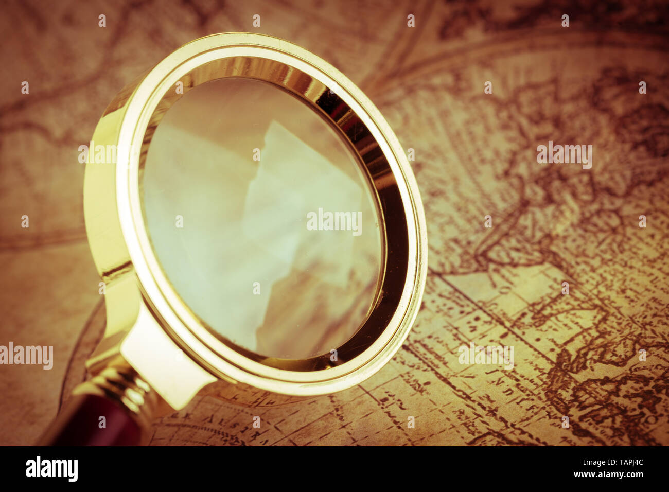 Old map with an magnifying glass Stock Photo - Alamy