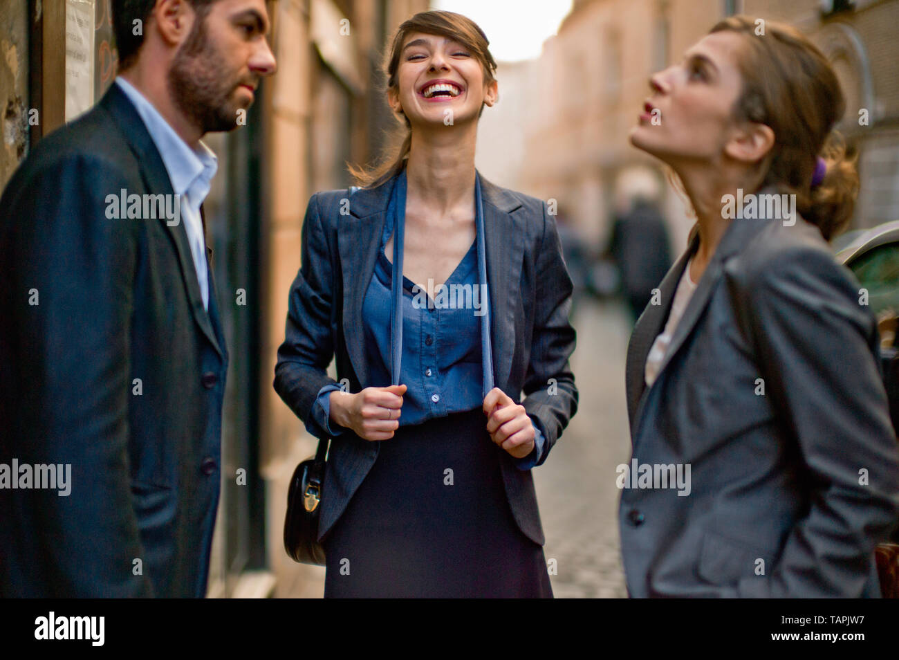 Happy young businesswoman smiling as her colleagues argue Stock Photo ...