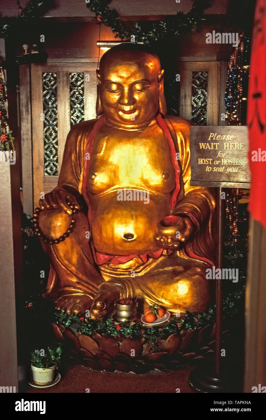 A golden statue commonly known as the Fat Buddha welcomes diners at the ...