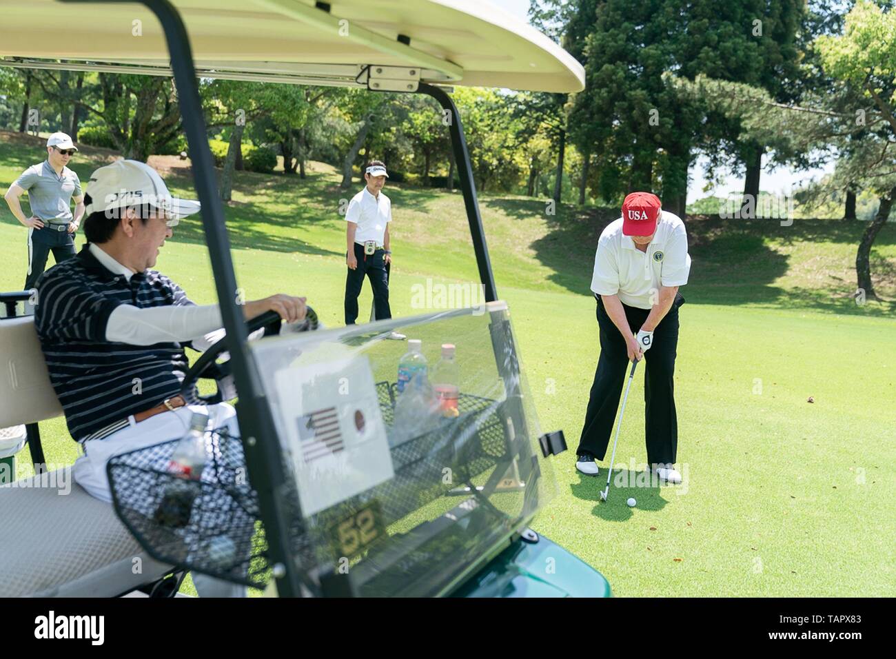 Japanese Prime Minister Shinzo Abe, left, watches from the cart as U.S ...