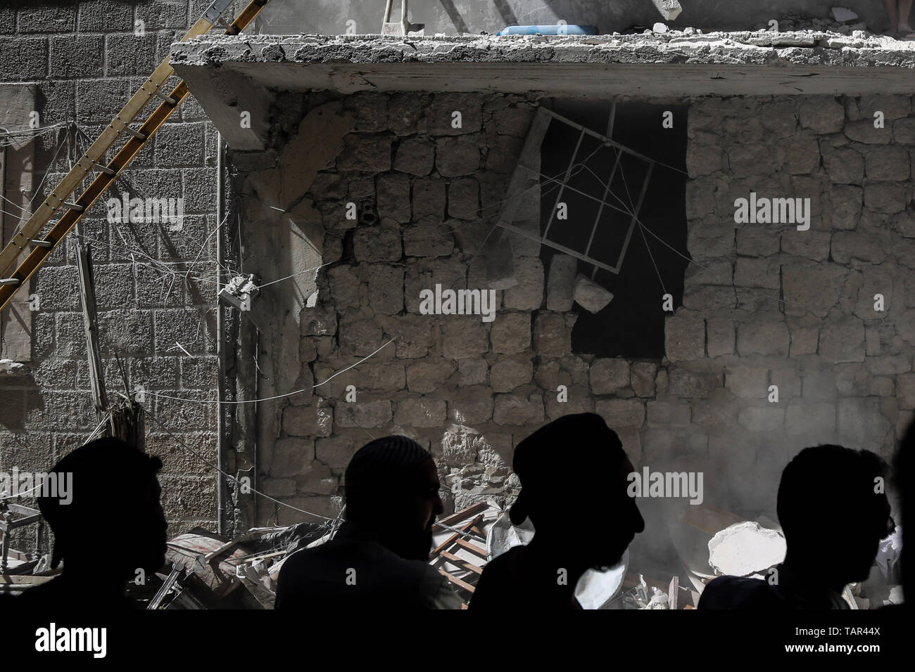 Ariha, Syria. 27th May, 2019. People stand in front of a building that ...