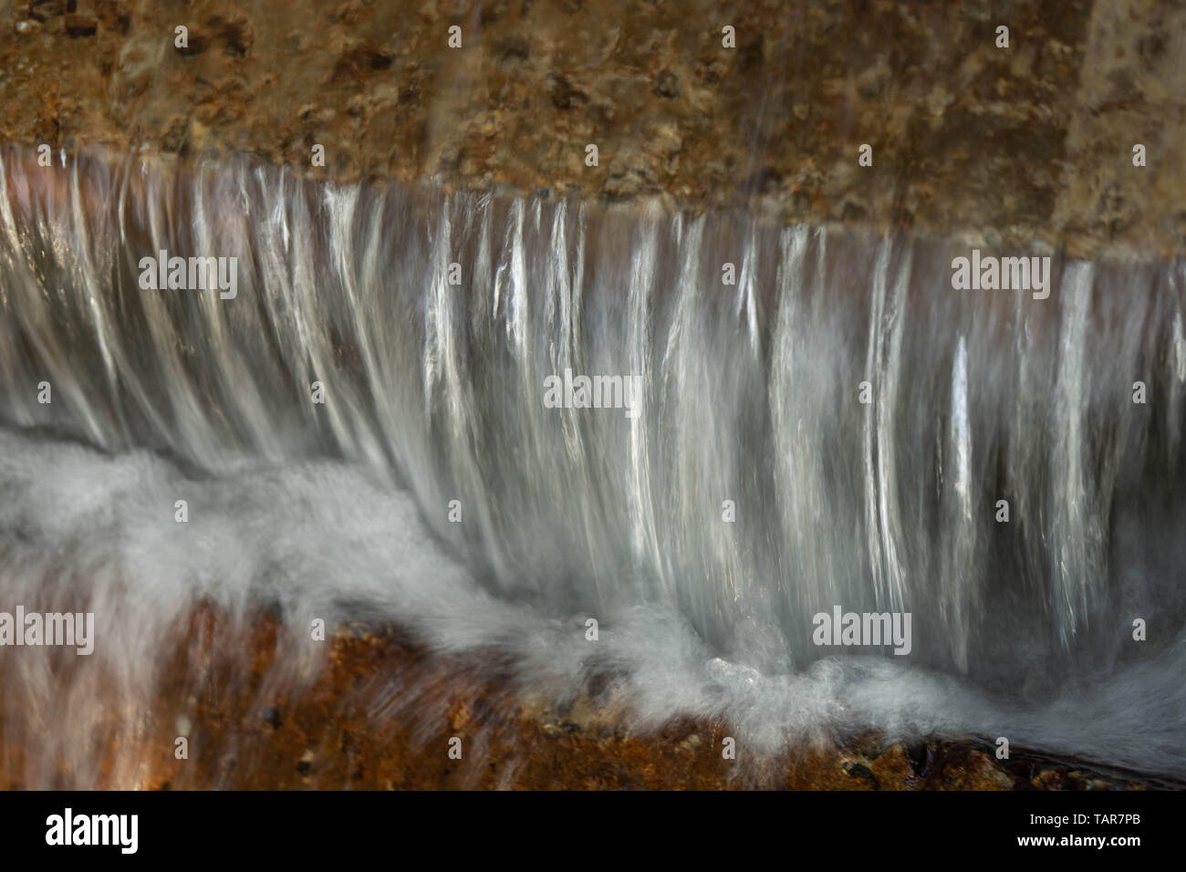 A stream of water, a waterfall formed on a flooded concrete staircase ...
