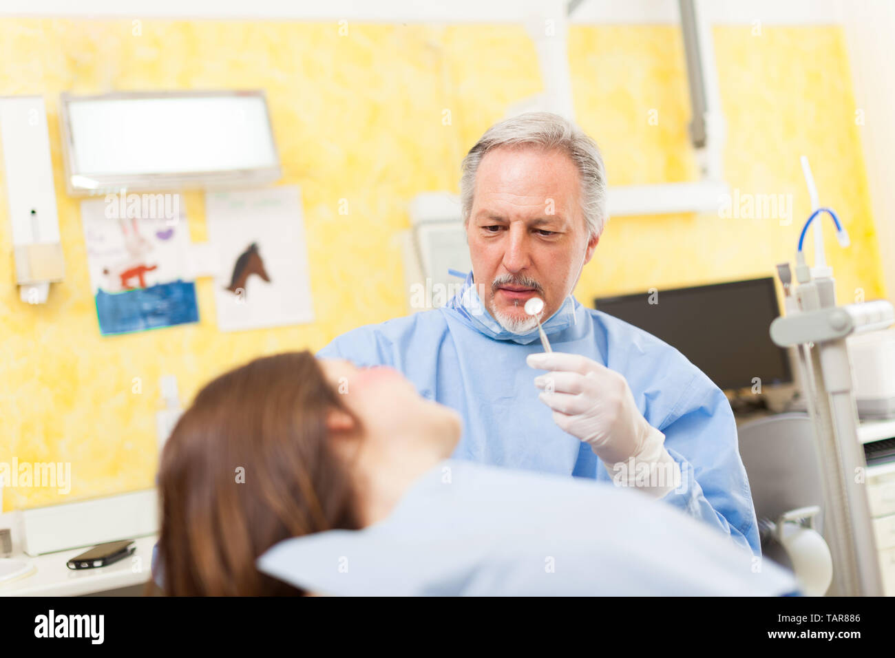 Dentist examining female patient tools hi-res stock photography and ...