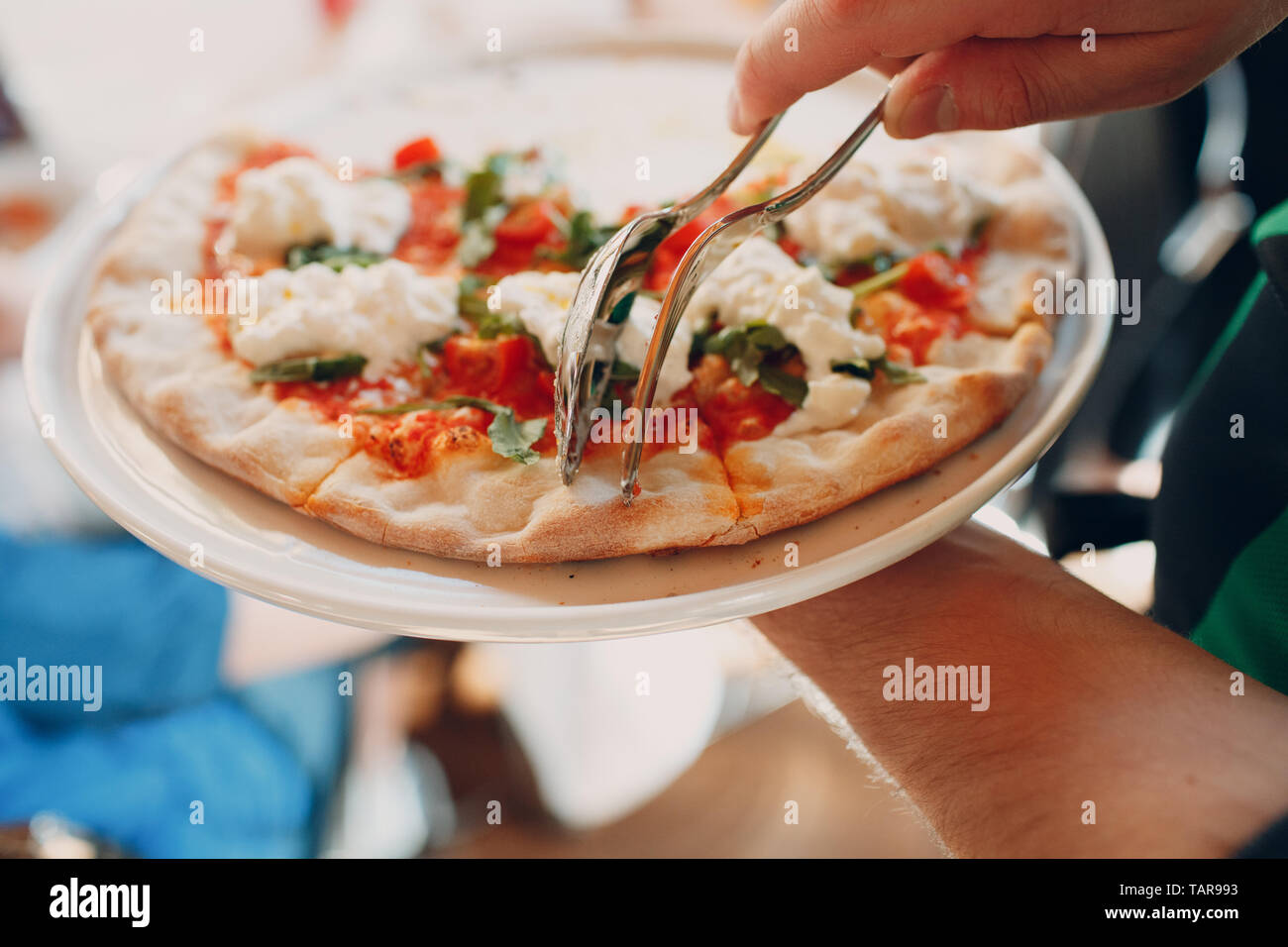The waiter serves pizza on a dish Stock Photo - Alamy