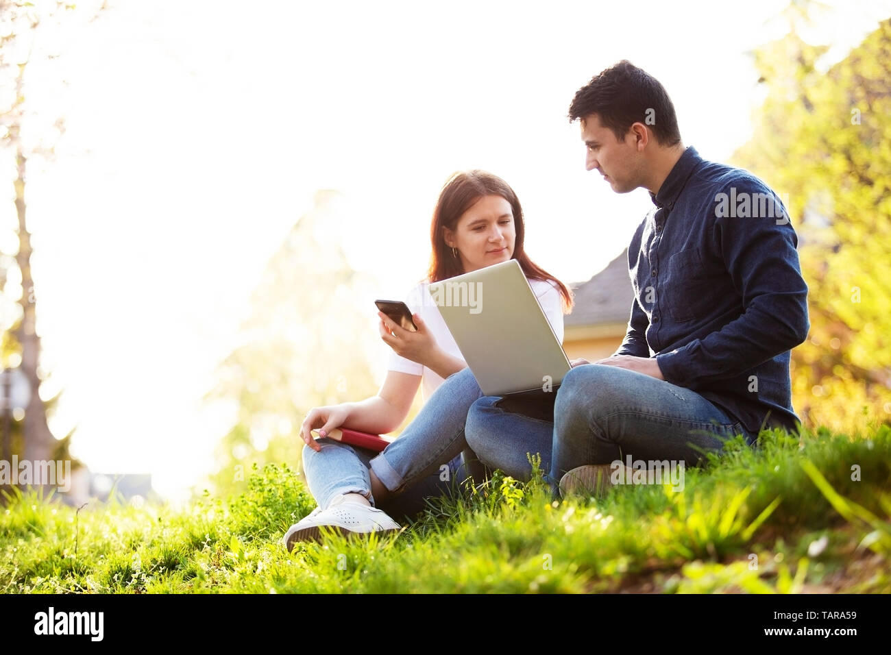 Students using laptop and mobile phone learning for exam together in a ...
