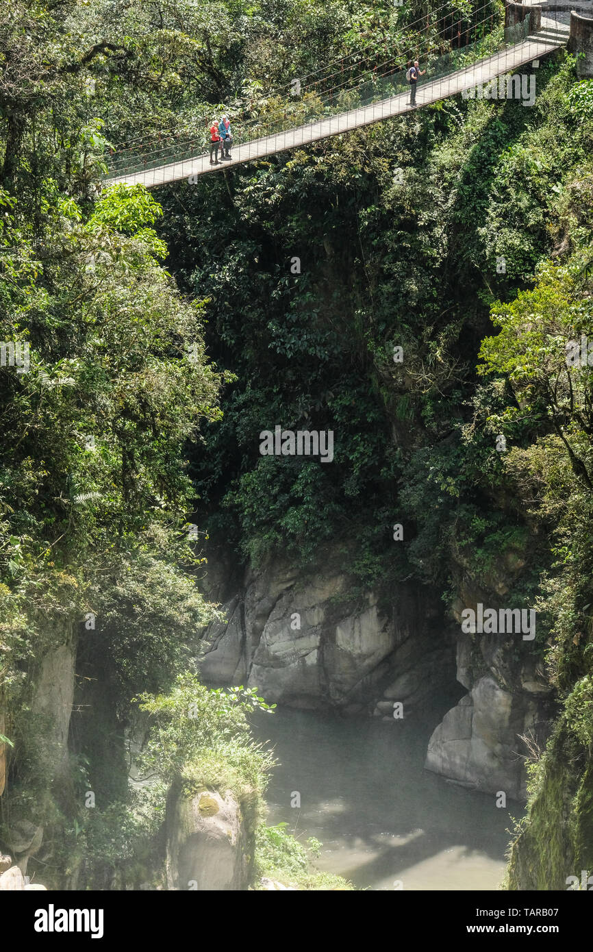 Tourists on suspension bridge over a deep canyon gorge at Pailin de ...