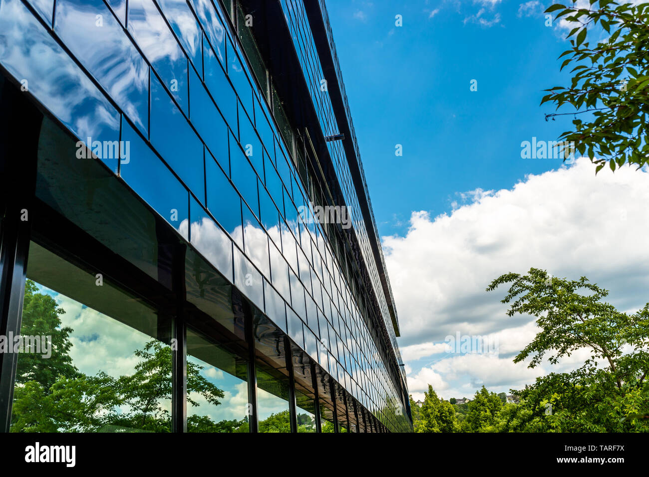 The facade of a modern building made of glass, blue panels in which the ...