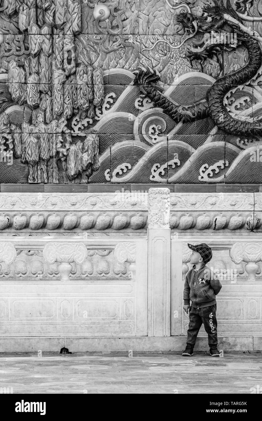 A little Chinese boy posing in front of Nice Dragon Screen in Forbidden ...
