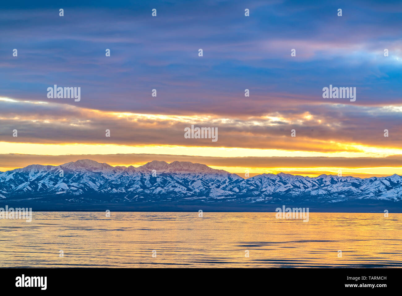 Panoramic view of a shiny lake and mountain covered with sharp white ...