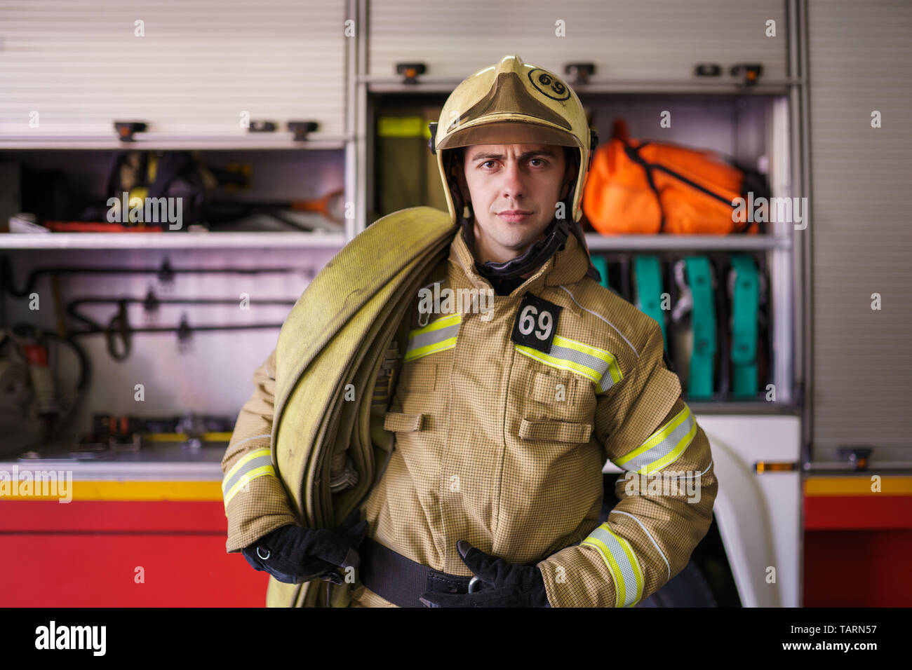 Photo of man fireman in helmet on background of fire truck at fire ...