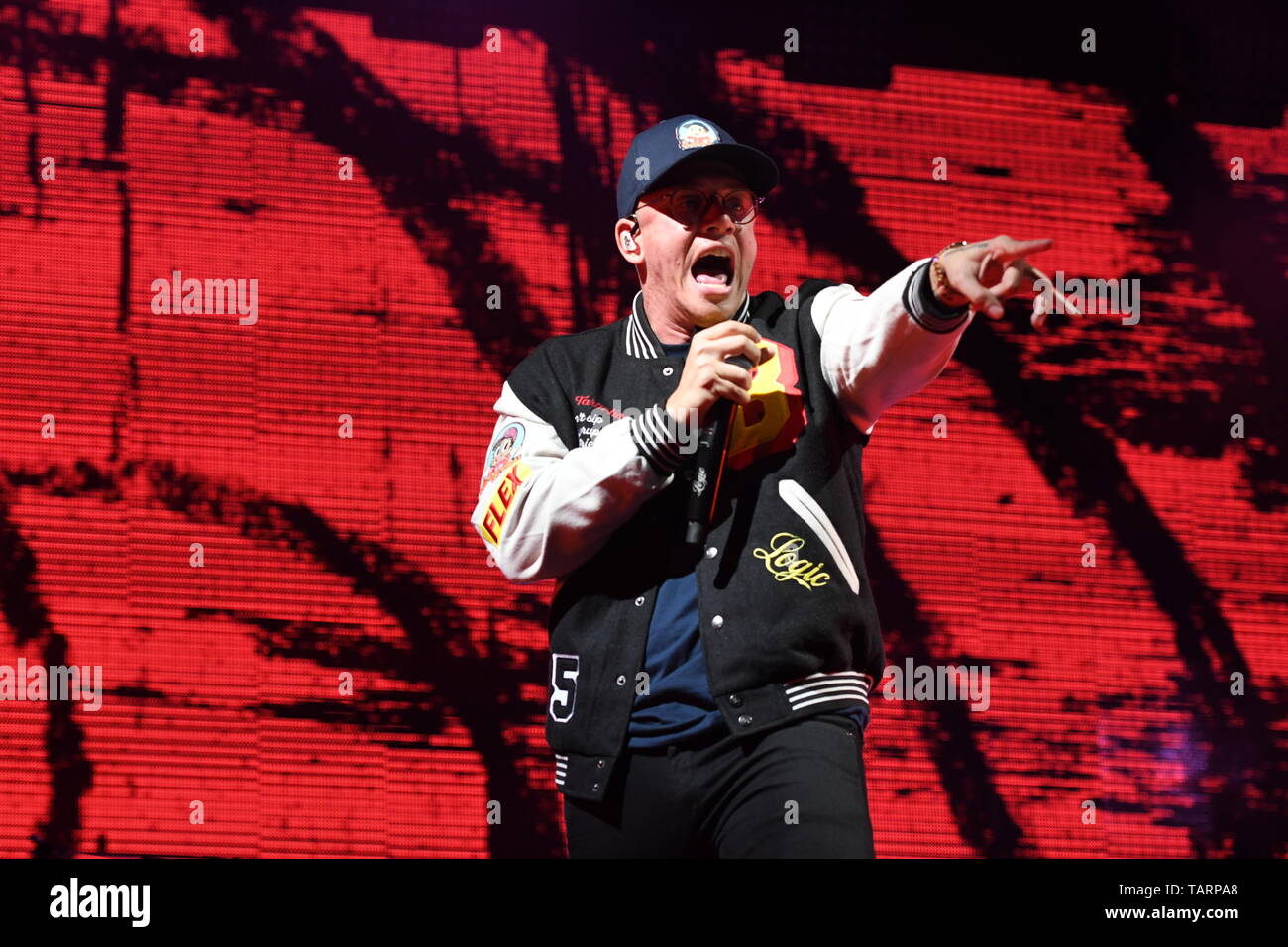 Rapper Logic is shown performing on stage during a live concert ...