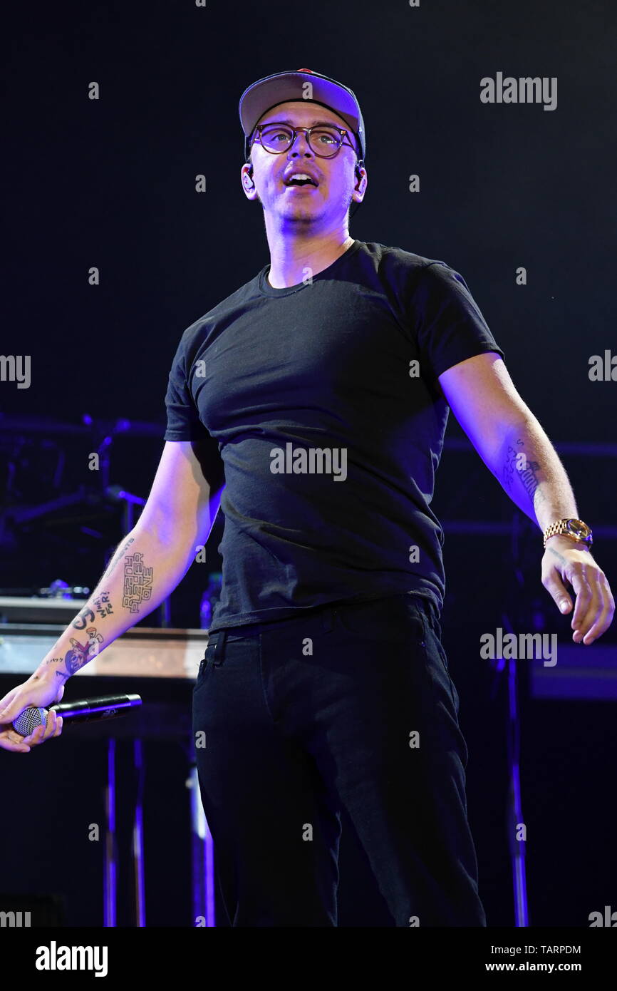 Rapper Logic is shown performing on stage during a live concert ...