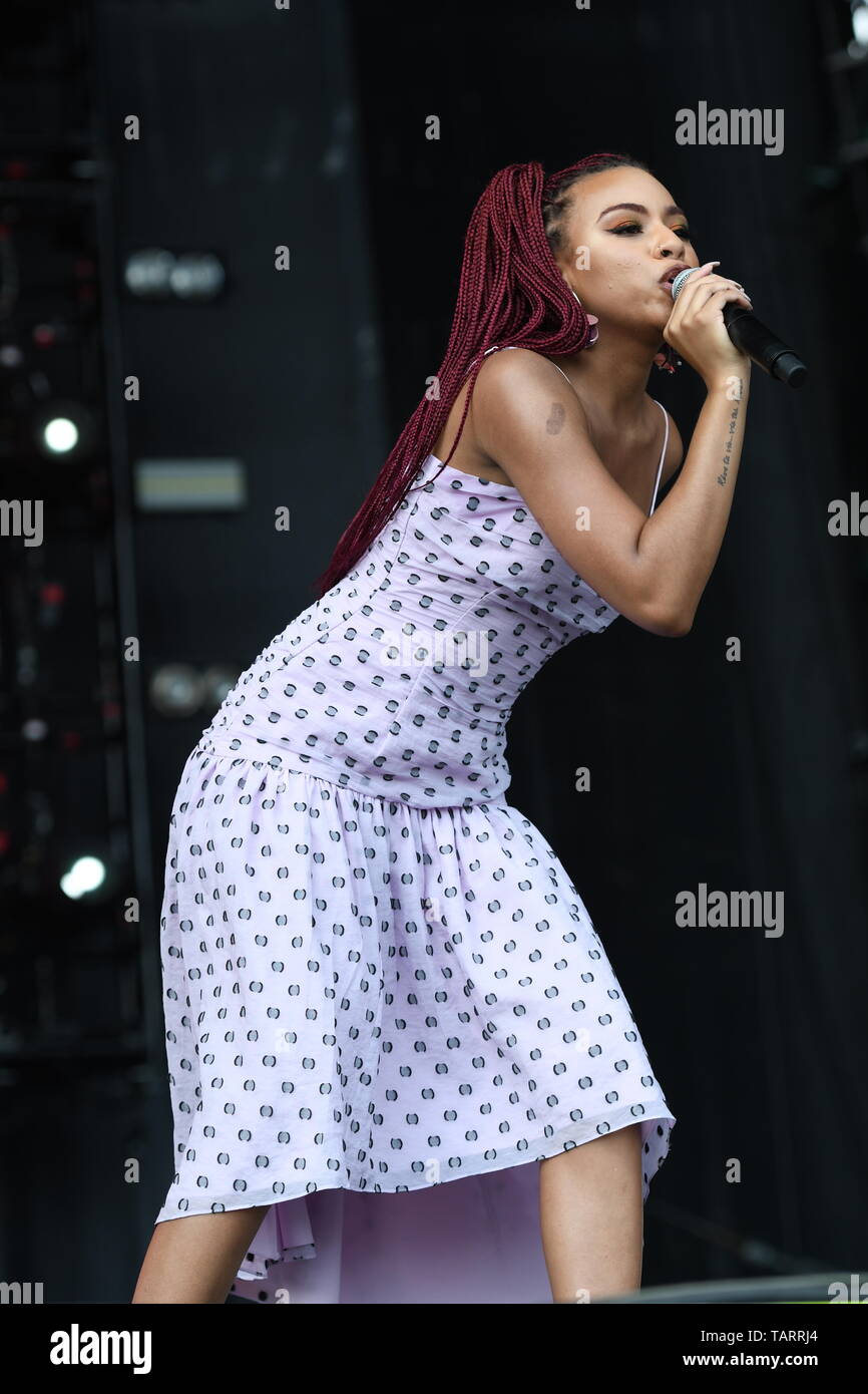 Singer Ravyn Lenae is shown performing on stage during a live concert ...