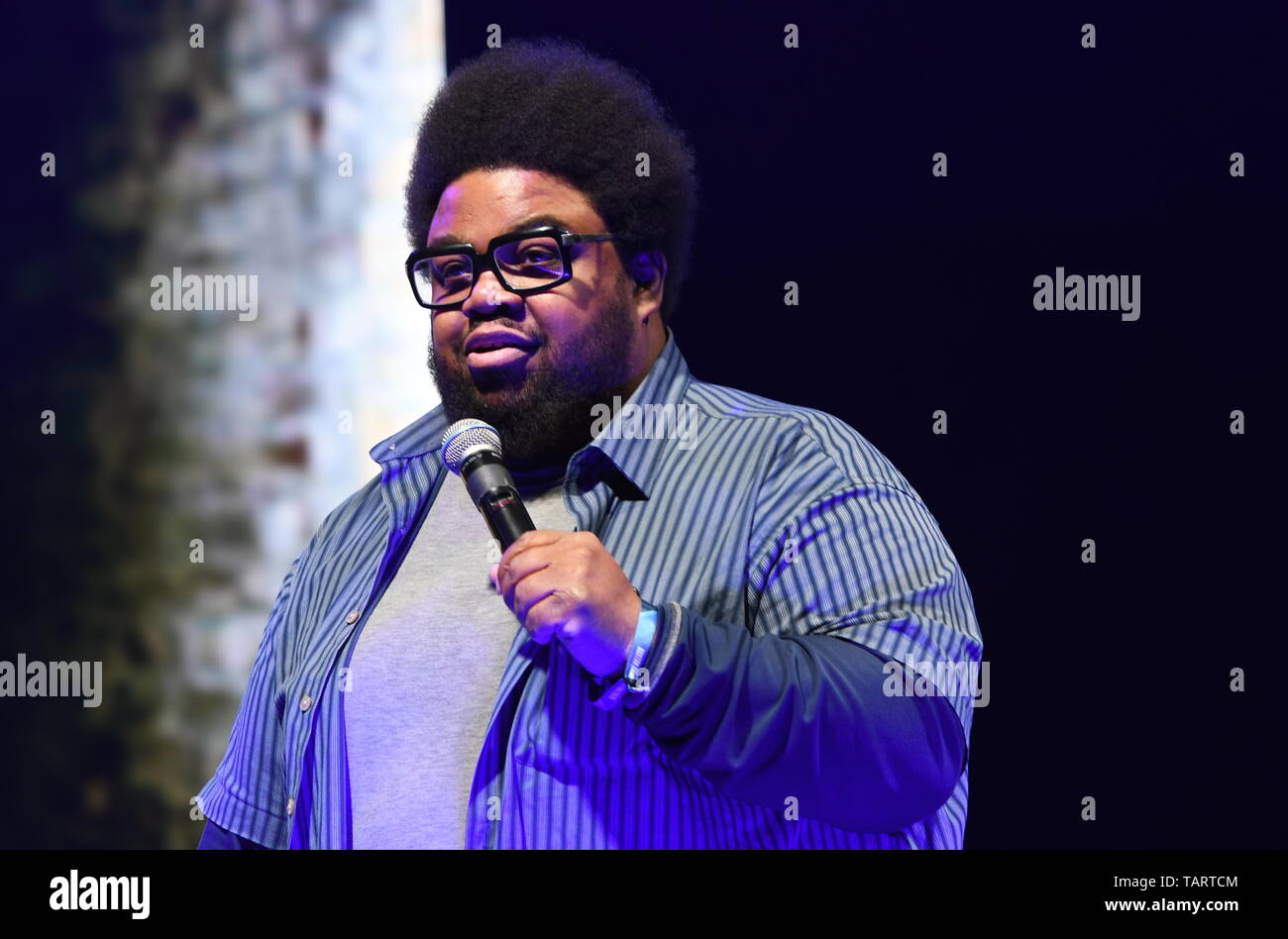 Comedian Lamont Price is shown performing on stage during a "live ...