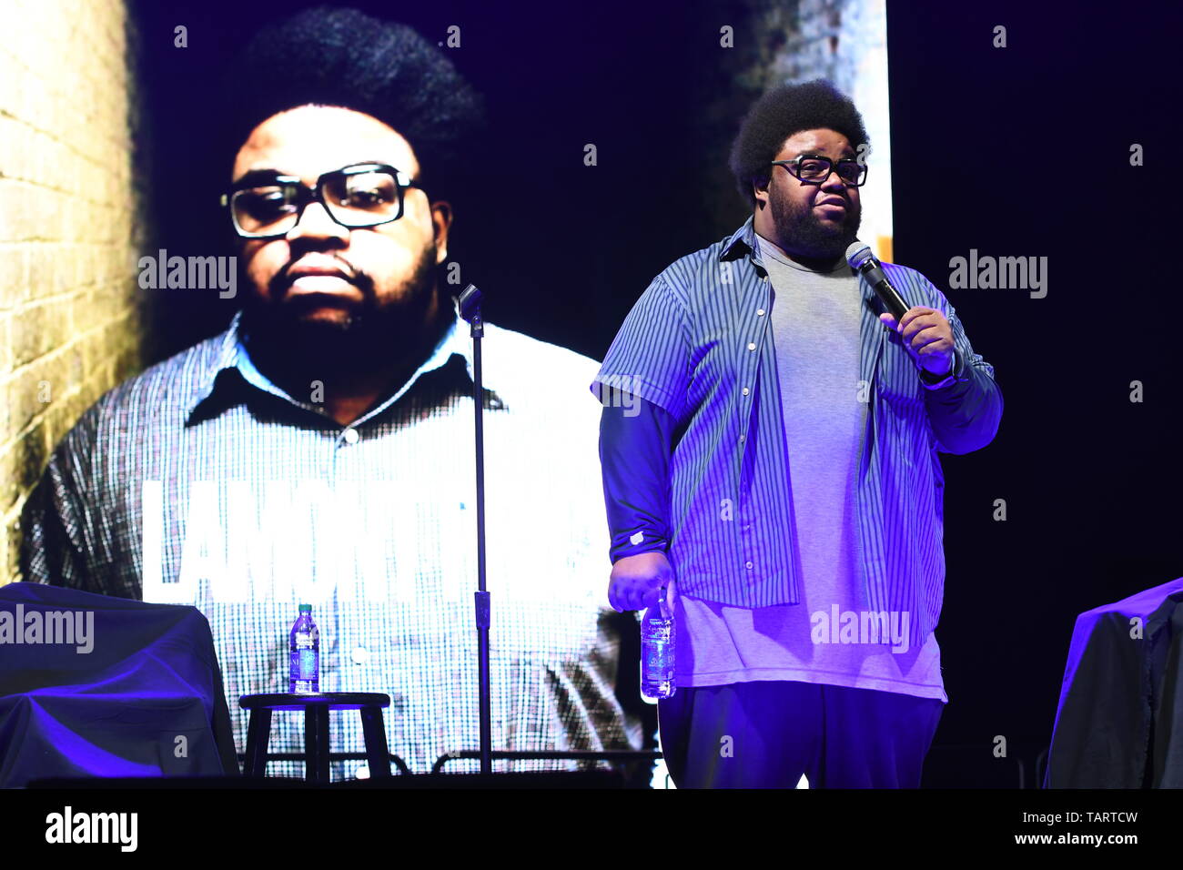 Comedian Lamont Price is shown performing on stage during a "live ...