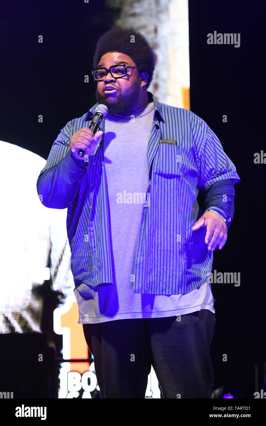 Comedian Lamont Price is shown performing on stage during a "live ...