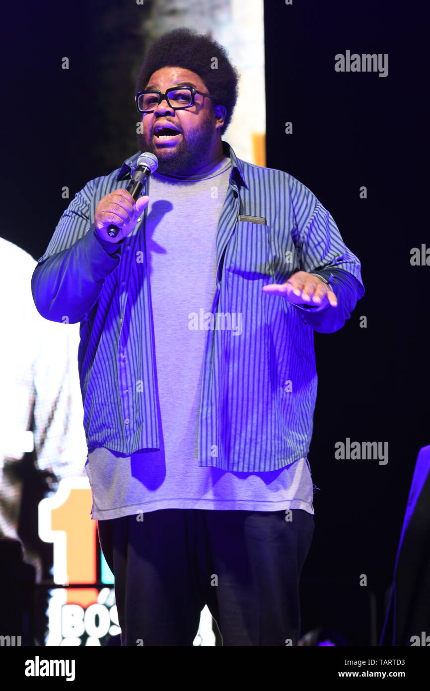 Comedian Lamont Price is shown performing on stage during a "live ...