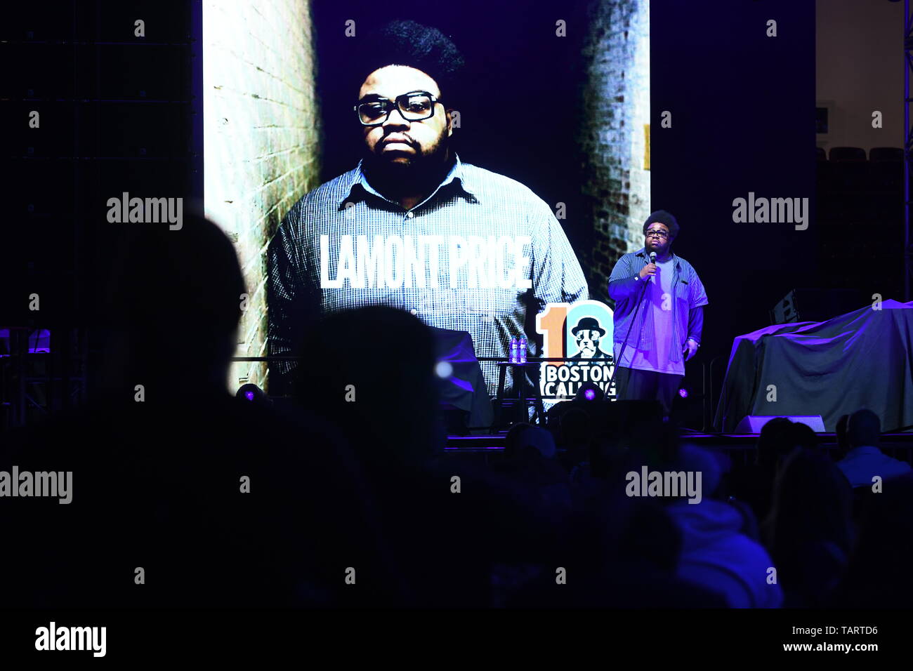 Comedian Lamont Price is shown performing on stage during a "live ...