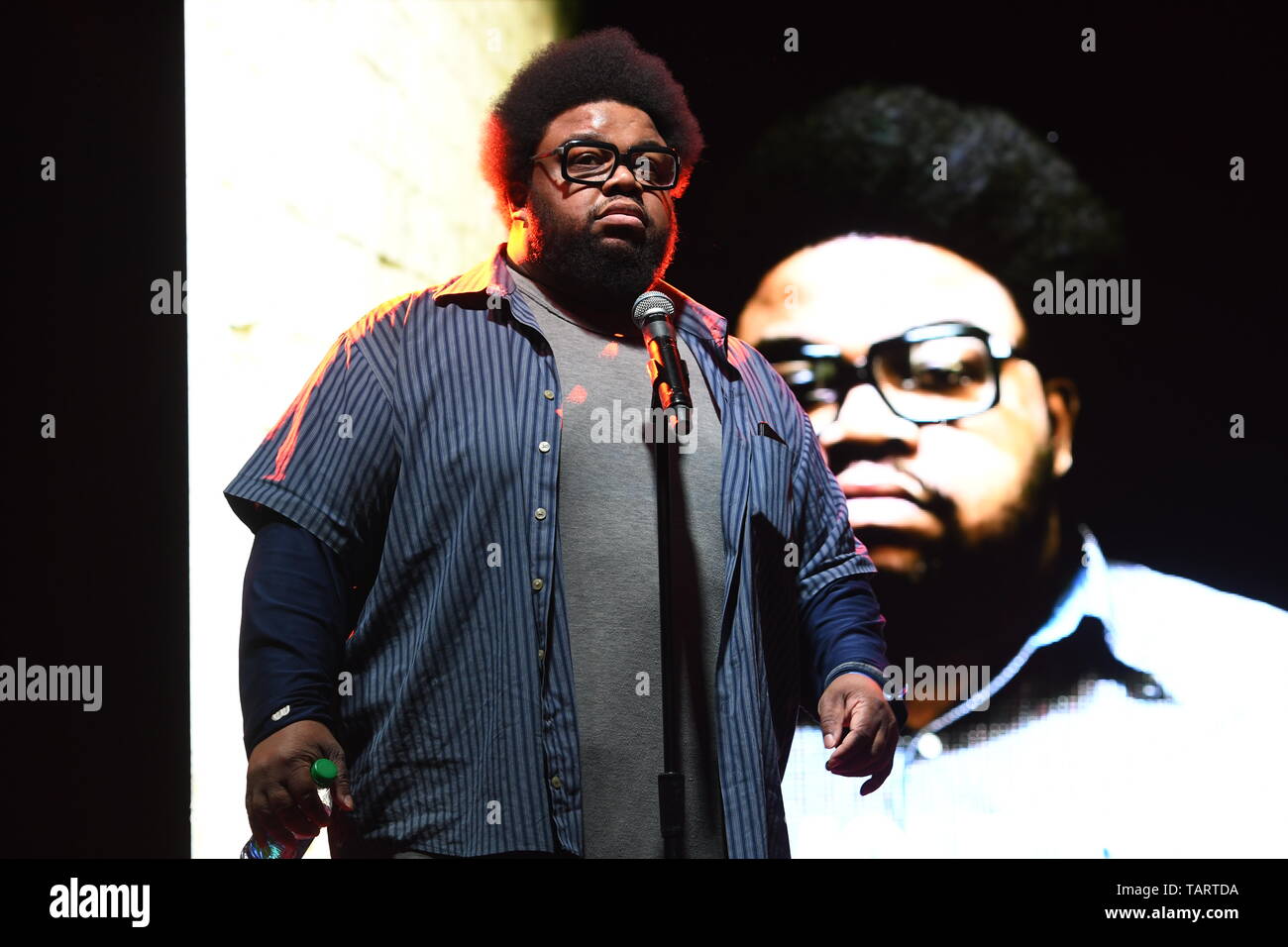 Comedian Lamont Price is shown performing on stage during a "live ...