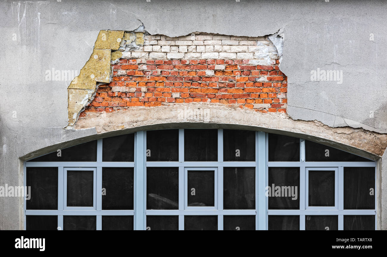 damaged grey plastered wall with damaged bricks and chipped stucco ...