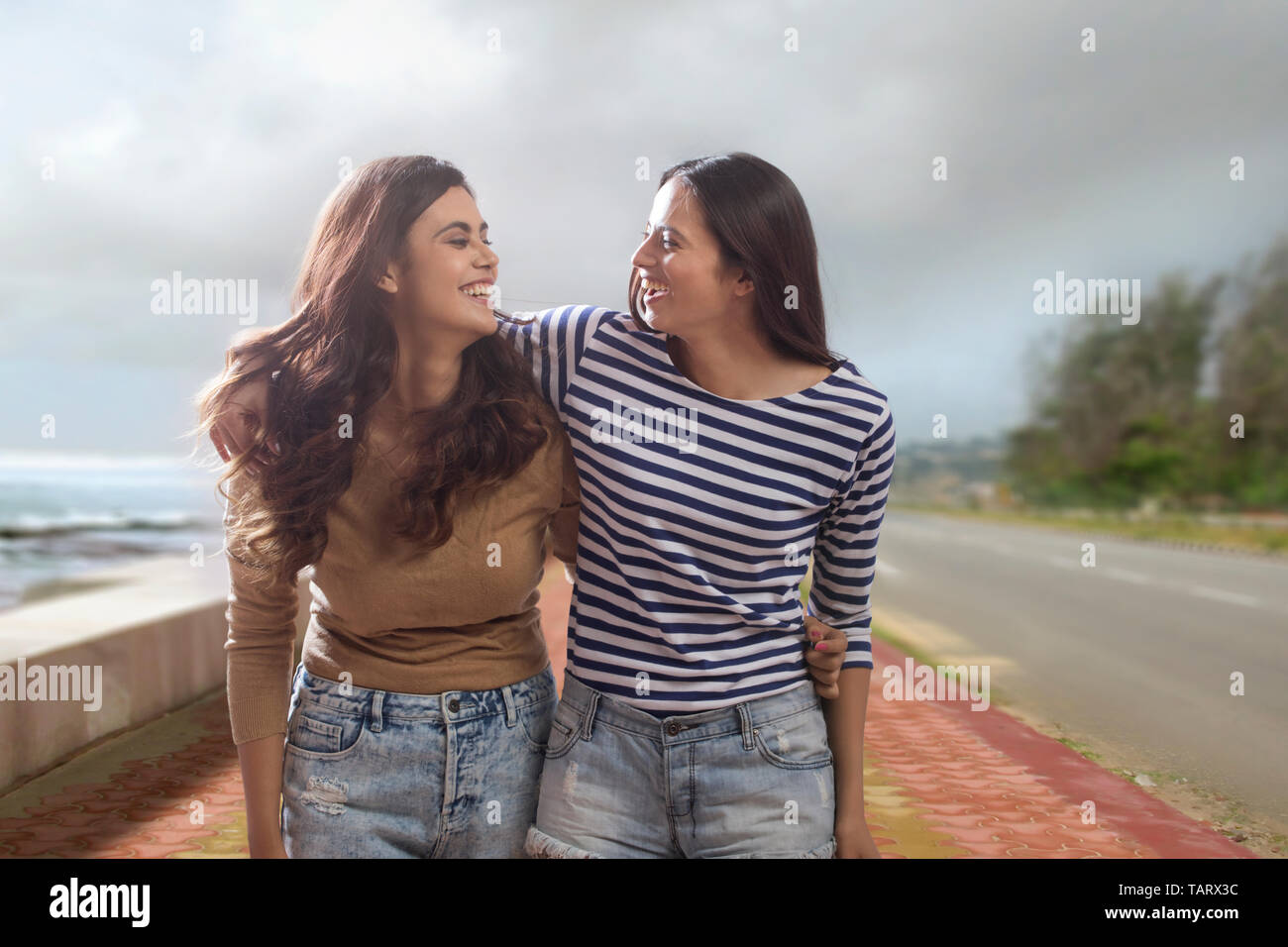 Two young woman standing roadside looking view hi-res stock photography ...
