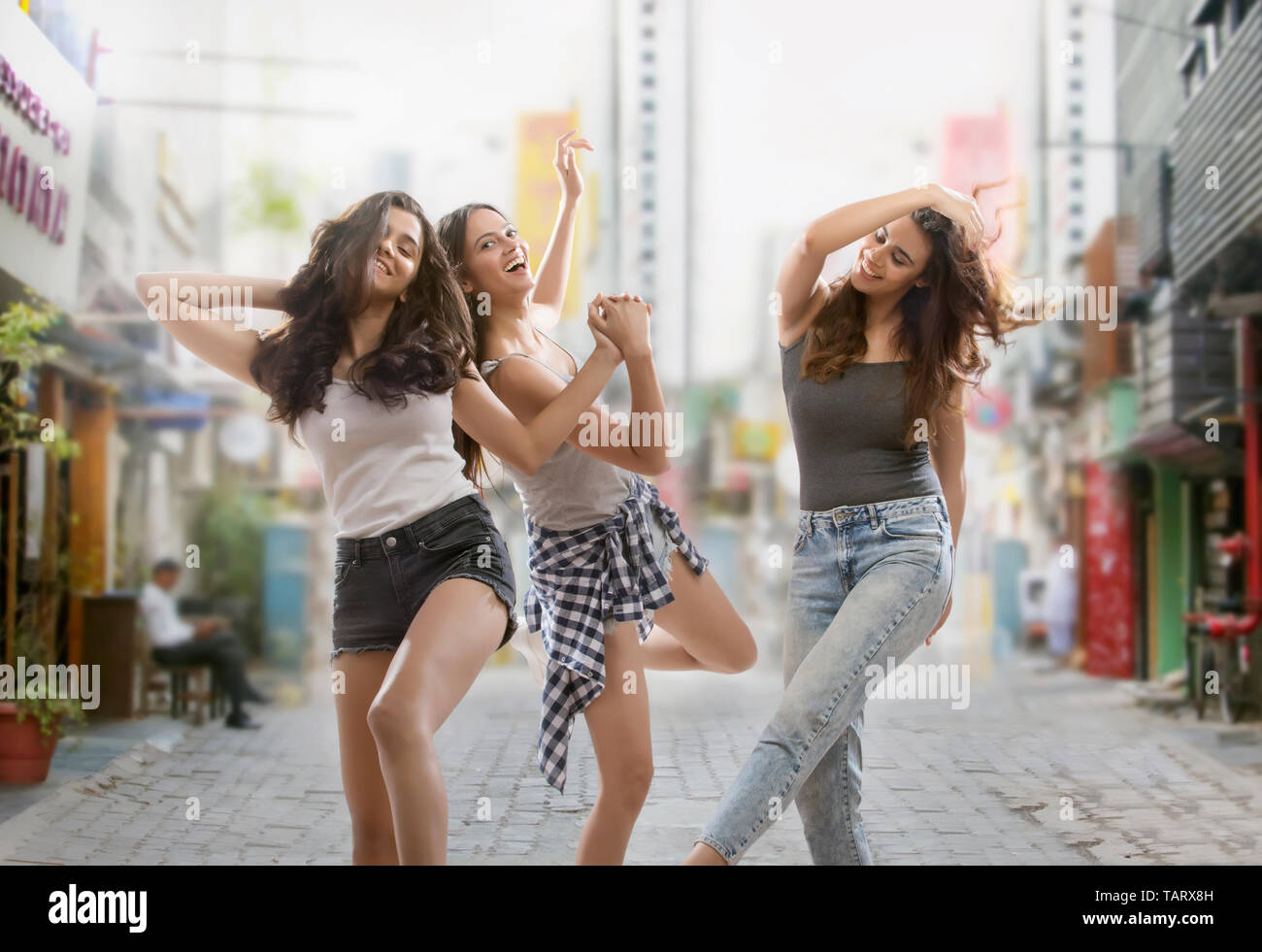 Three young women dancing on street Stock Photo - Alamy