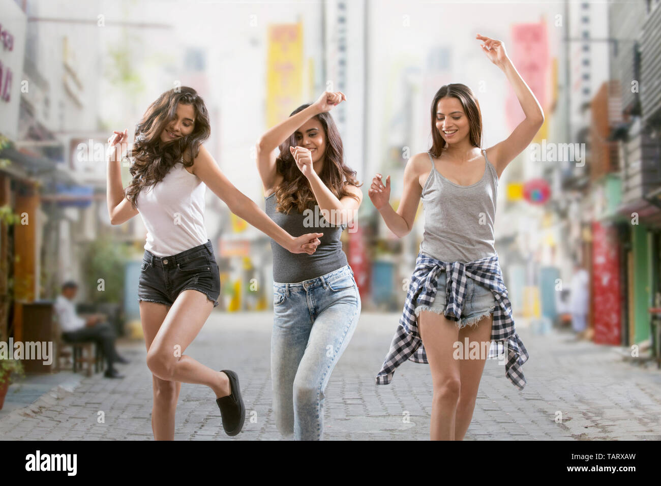 Three girl friends having fun dancing on street Stock Photo - Alamy