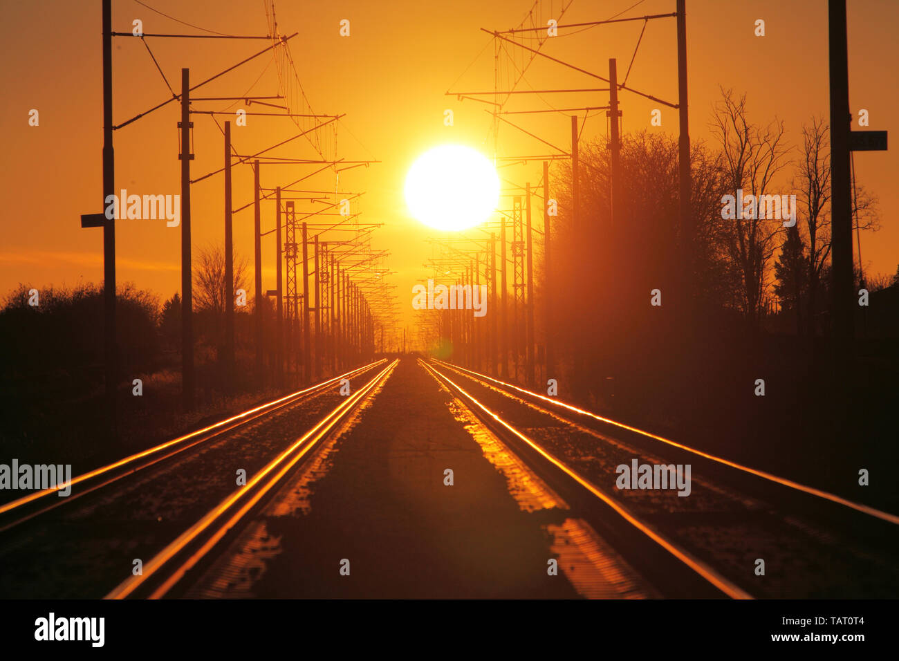 Railroad - Railway at sunset with sun Stock Photo - Alamy