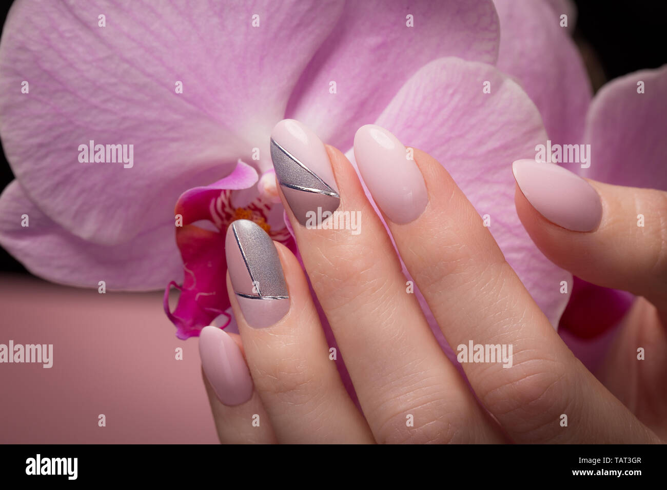 Purple neat manicure on female hands on flowers background. Nail design ...