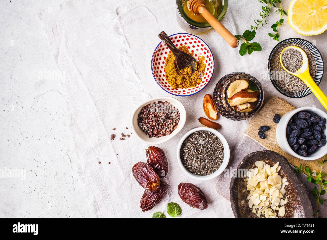 Flt lay of super foods - honey, dates, turmeric, lemon, nuts and chia ...