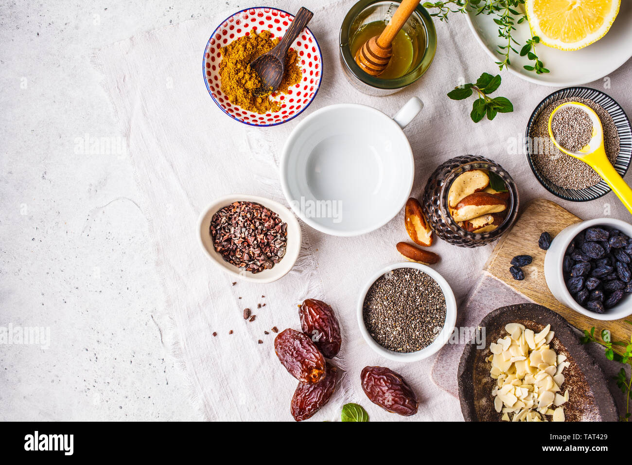 Flt lay of super foods - honey, dates, turmeric, lemon, nuts and chia ...