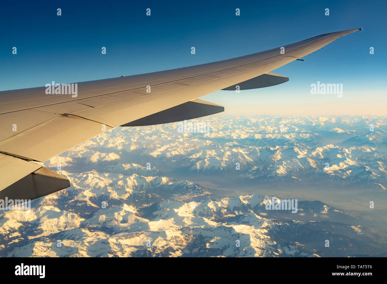 Wing of plane over mountain cover with white snow. Airplane flying on ...