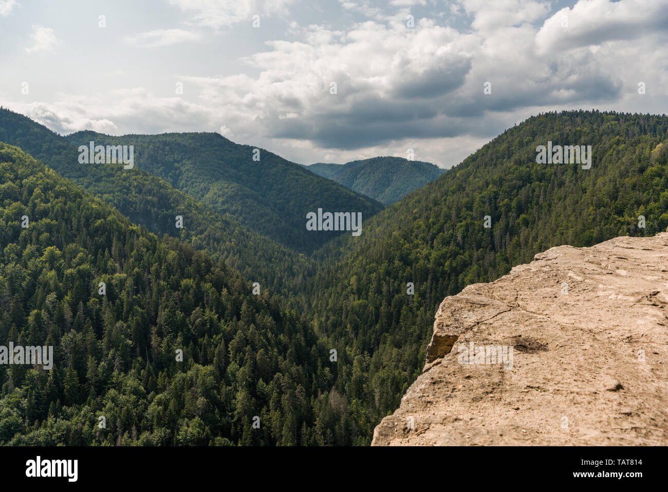 Rocky cliff, dark clouds and freen mountains from Tomasovsky vyhlad ...