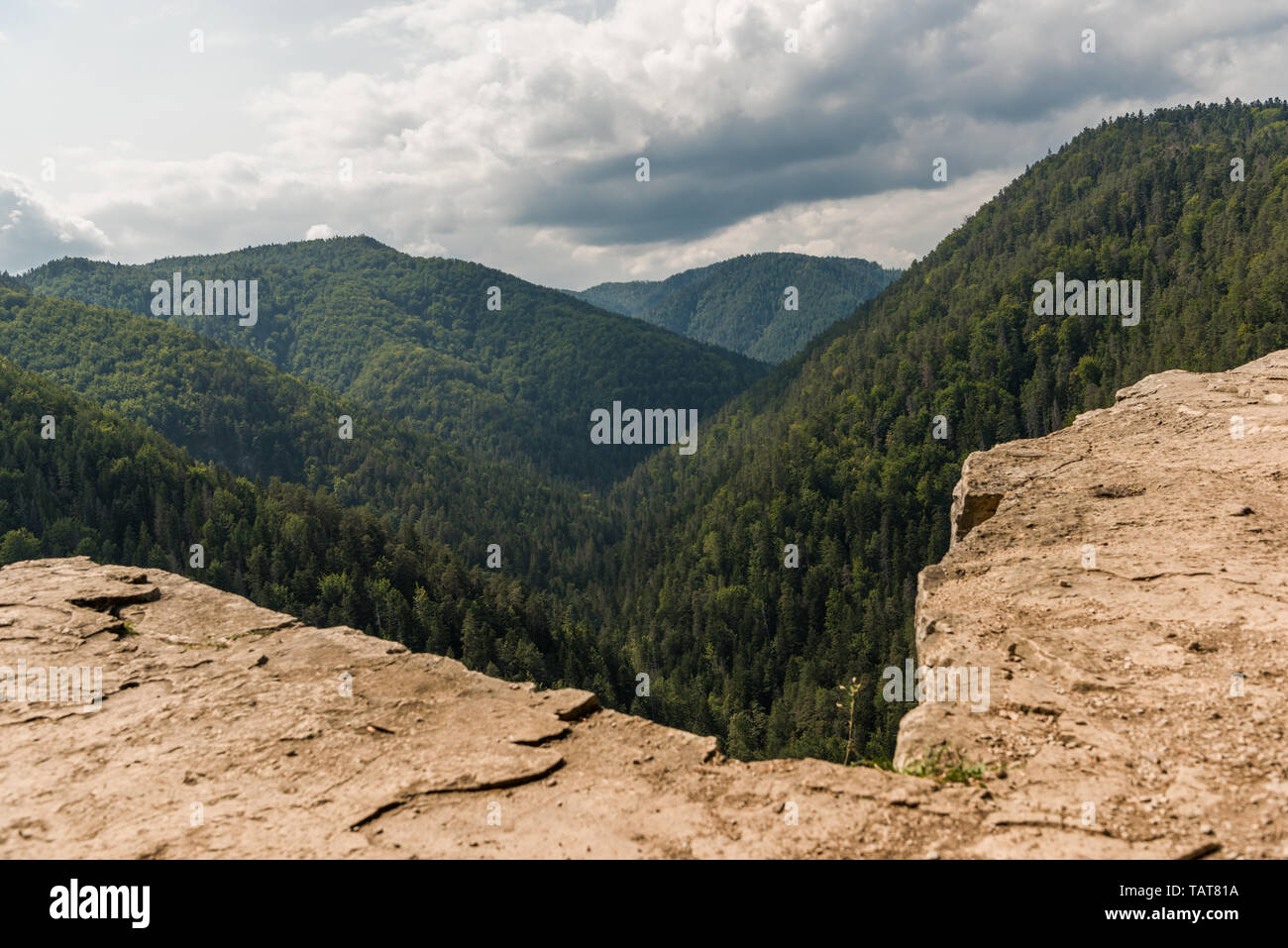 Rocky cliff, dark clouds and freen mountains from Tomasovsky vyhlad ...