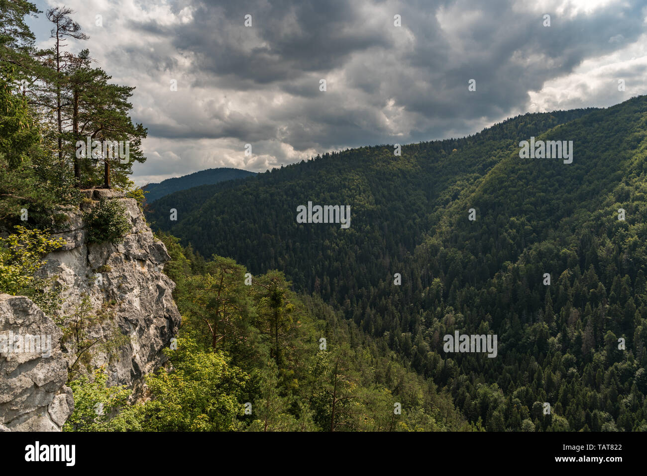 Rocky cliff, dark clouds and freen mountains from Tomasovsky vyhlad ...