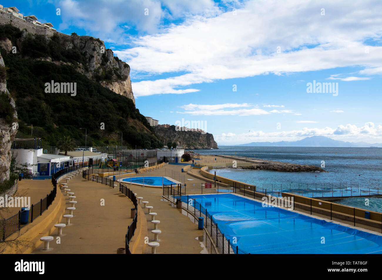Coast of Gibraltar rock and clouds sky swimming pool seats seating ...