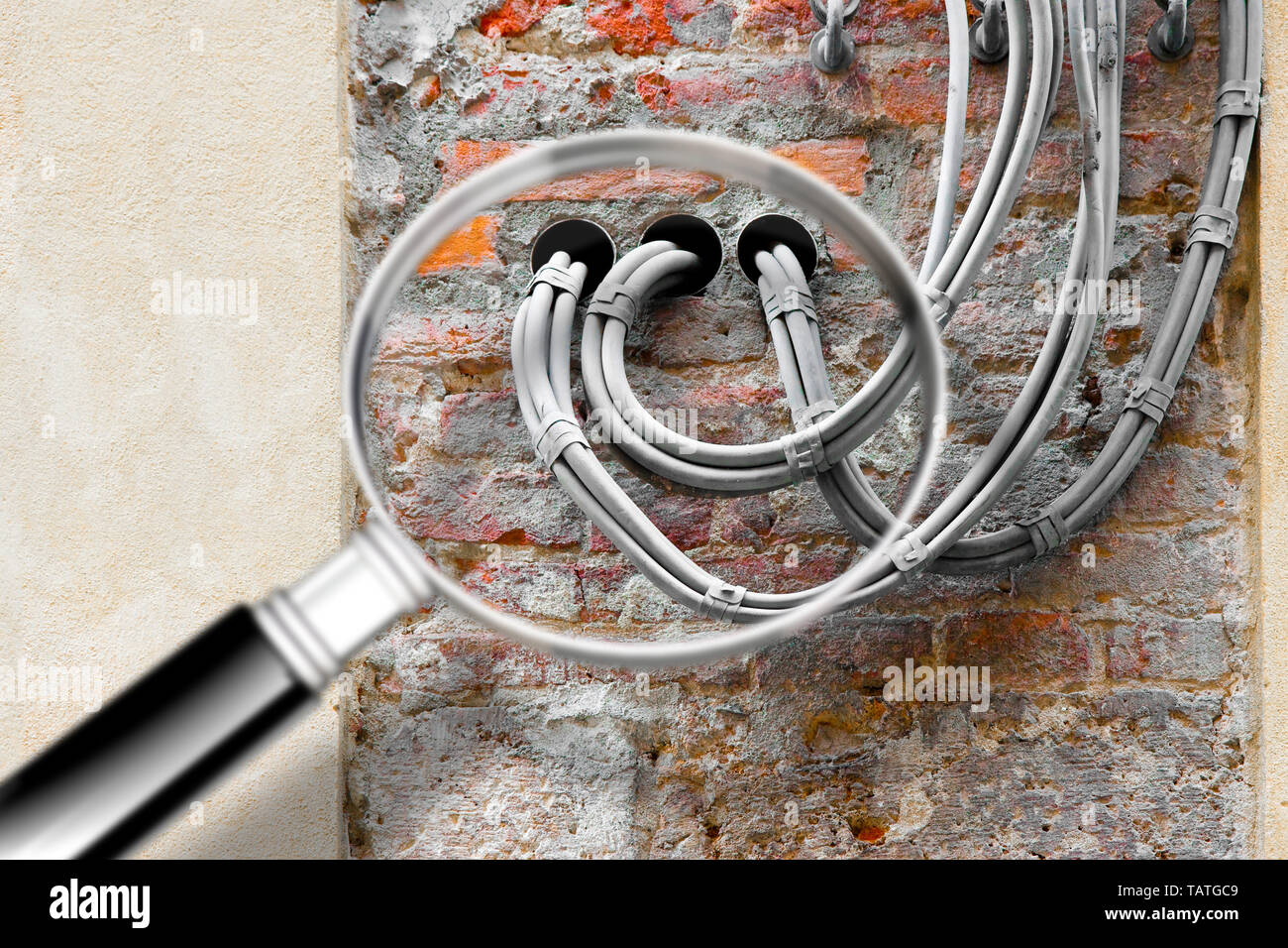 Electrical power cables and telephone cables against a brick and ...