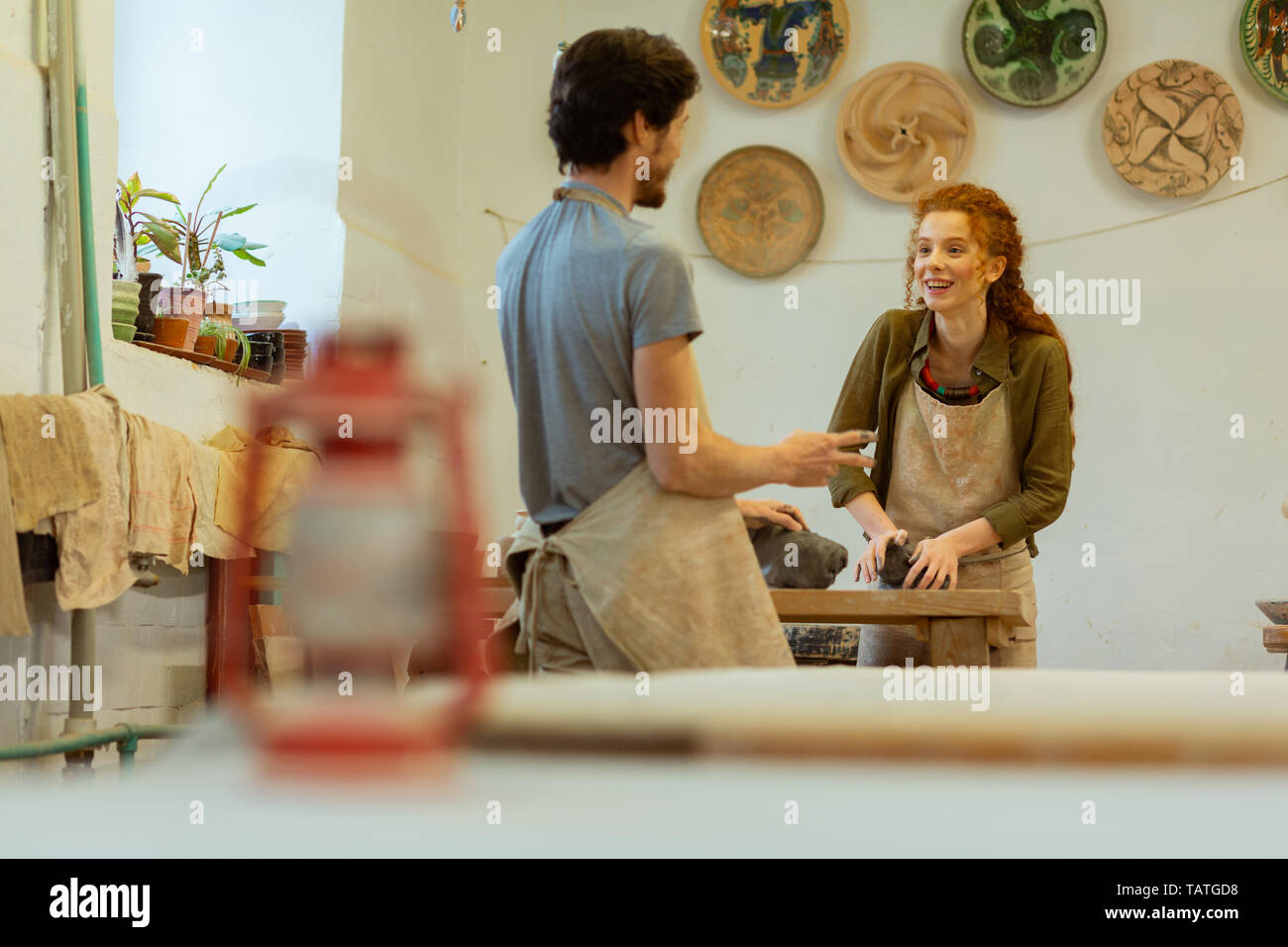 Skilled pottery workers. Talkative pleasant colleagues being kind to ...