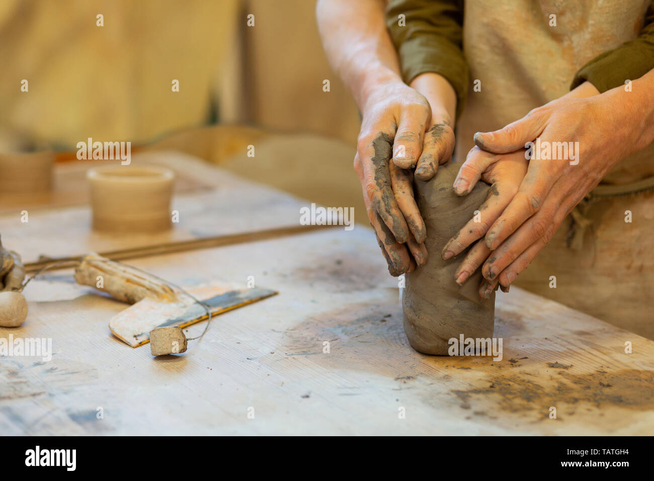 Man tightly pressing. Passionate couple dealing with wet piece of clay ...