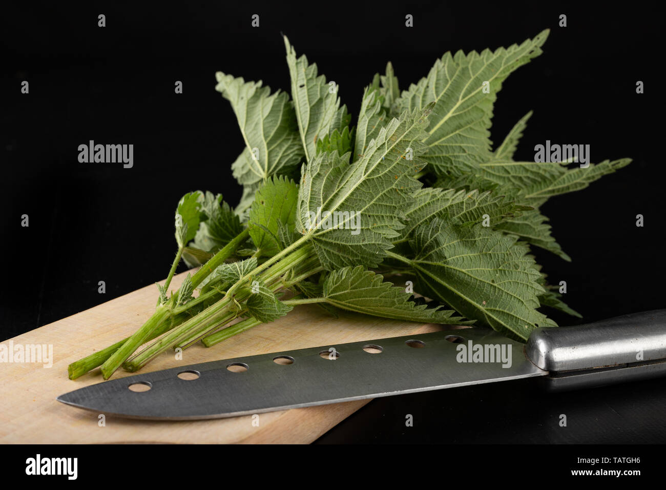 Large nettles shoots on a kitchen chopping board. Natural ways to ...