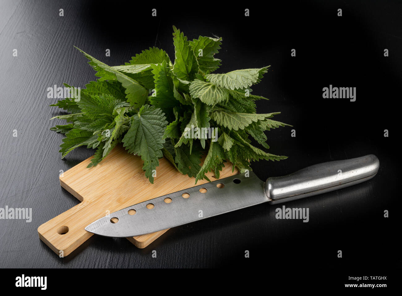Large nettles shoots on a kitchen chopping board. Natural ways to ...
