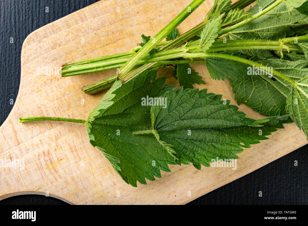 Large nettles shoots on a kitchen chopping board. Natural ways to ...